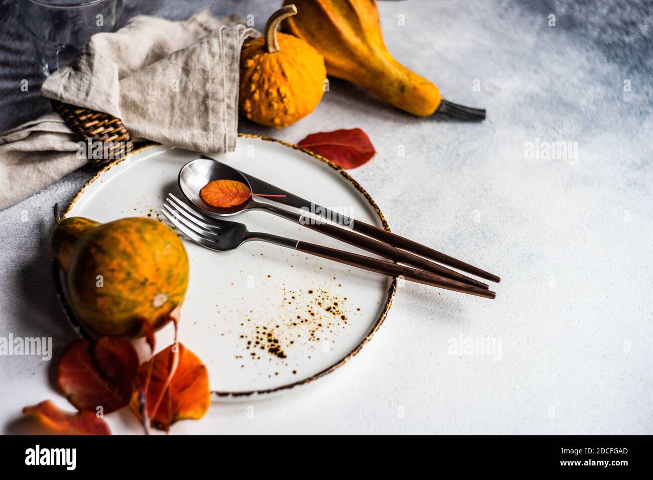 Autumnal place setting with yellow and red leaves on rustic background ...