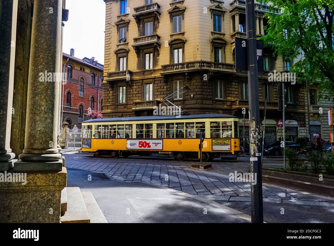 Milan street panorama with Milan trams, pedestrians and cars on a sunny ...