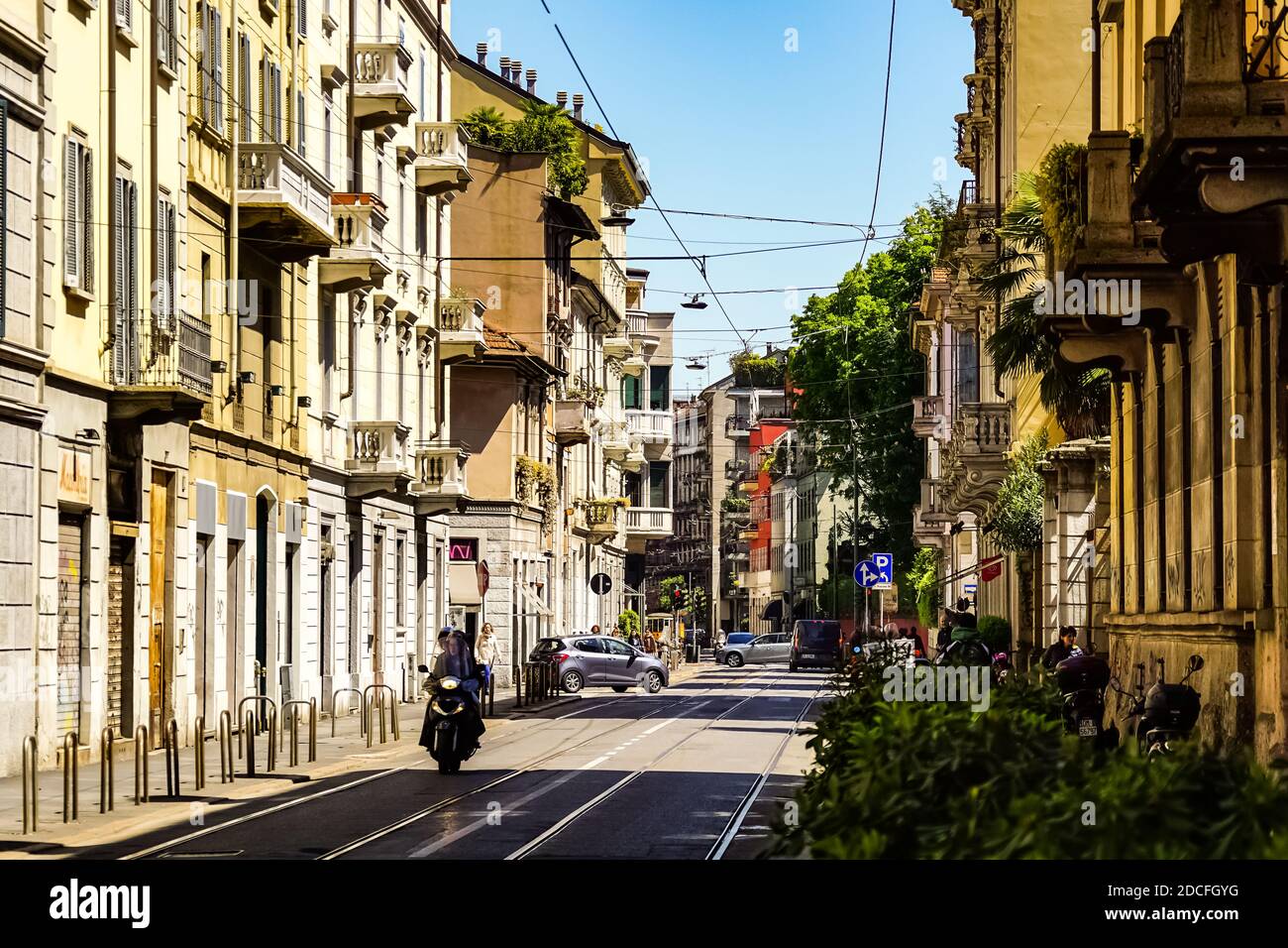 Milan street panorama with Milan trams, pedestrians and cars on a sunny ...