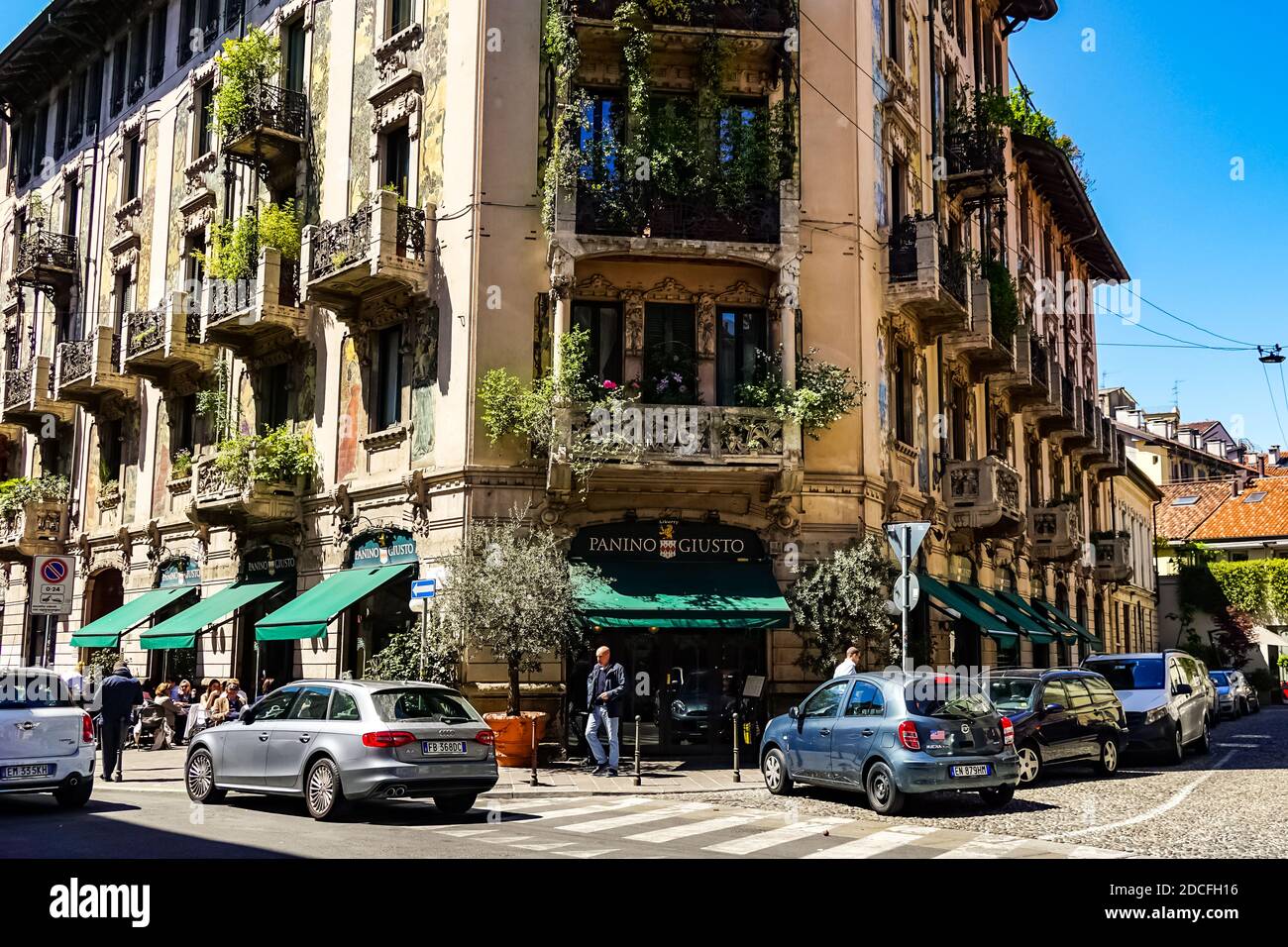 Milan street panorama with Milan trams, pedestrians and cars on a sunny ...