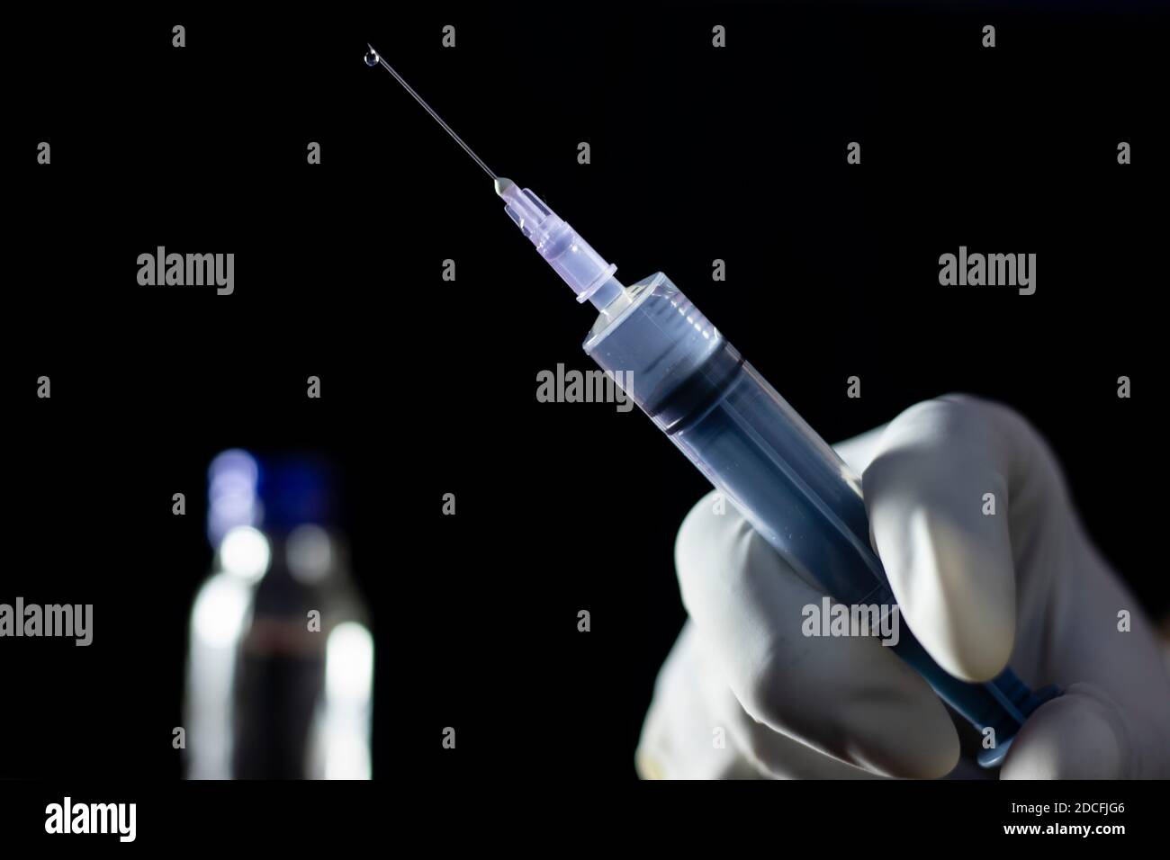 selective focus on injection syringe in human hand wearing gloves on ...