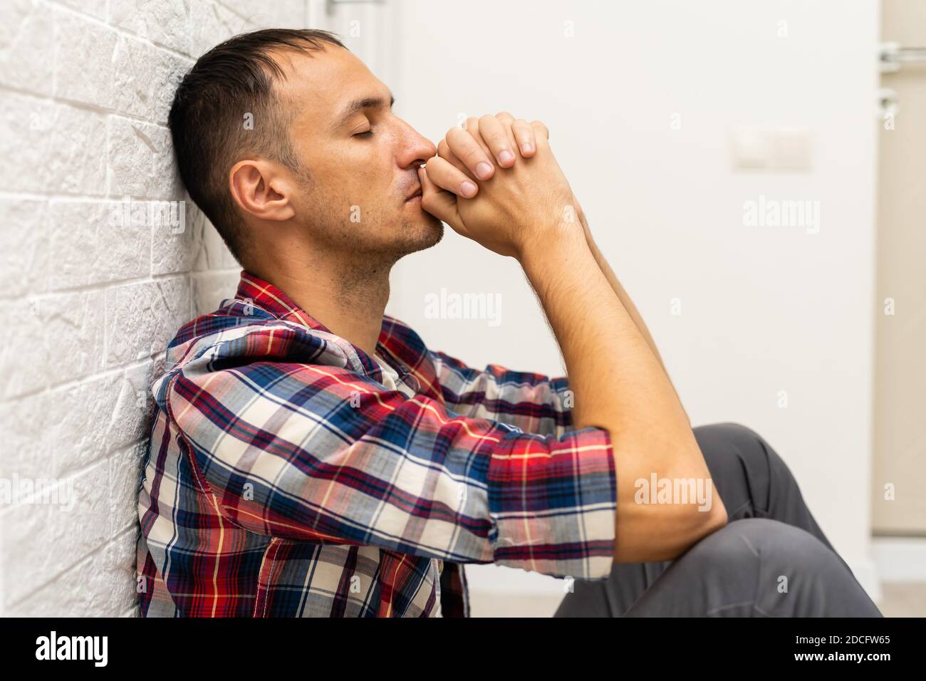 Feeling hopeless. Depressed young bearded man keeping eyes closed and ...