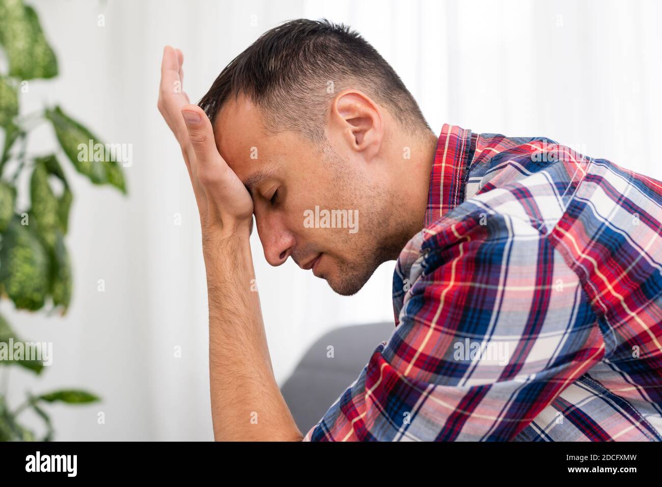 Thoughtful young man in the living room Stock Photo - Alamy