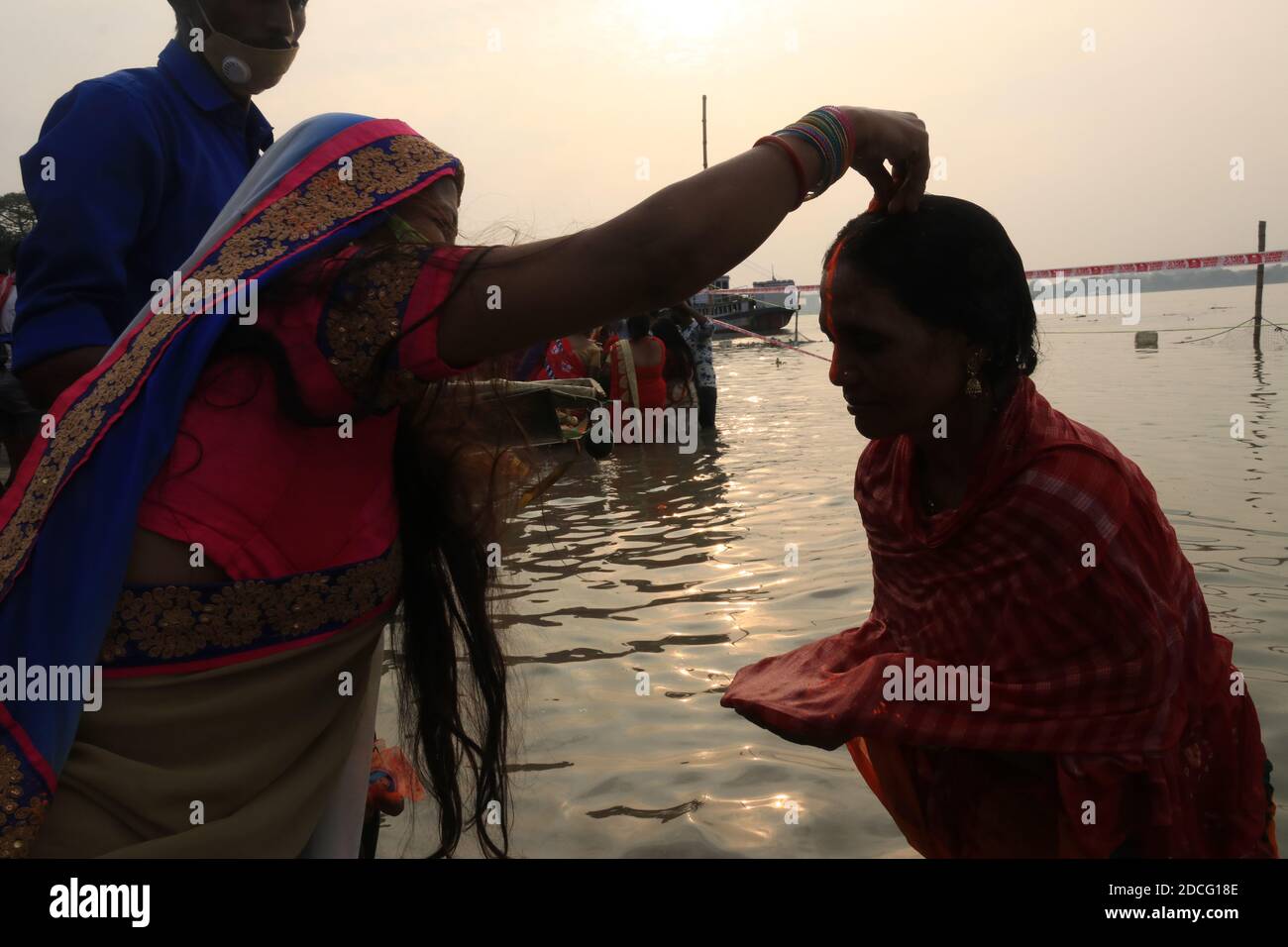 Hindu devotees worship the Sun god on the banks of the Ganges River ...