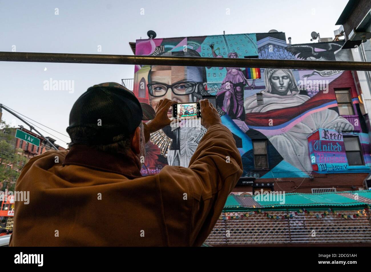A man takes photo with cell phone of completed mural Notorious RBG ...