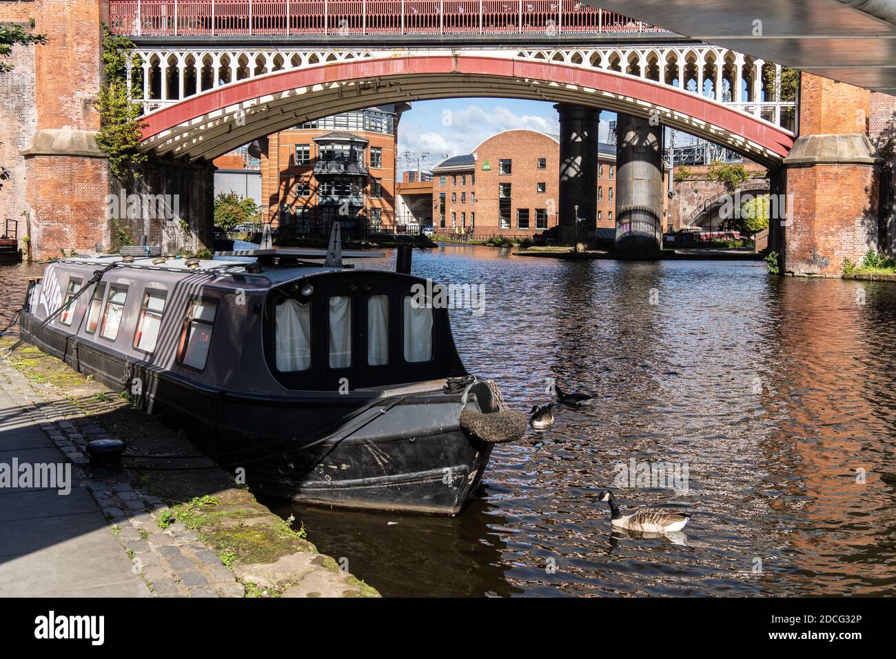 moored barge and victorian iron railway bridge, castlefield, manchester ...