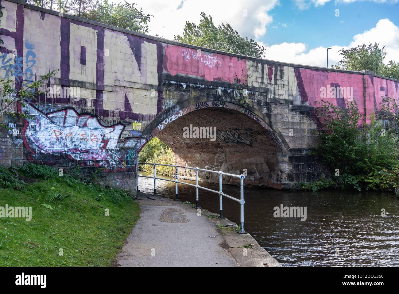 the bridgewater canal passes under a graffiti coverd bridge, manchester ...