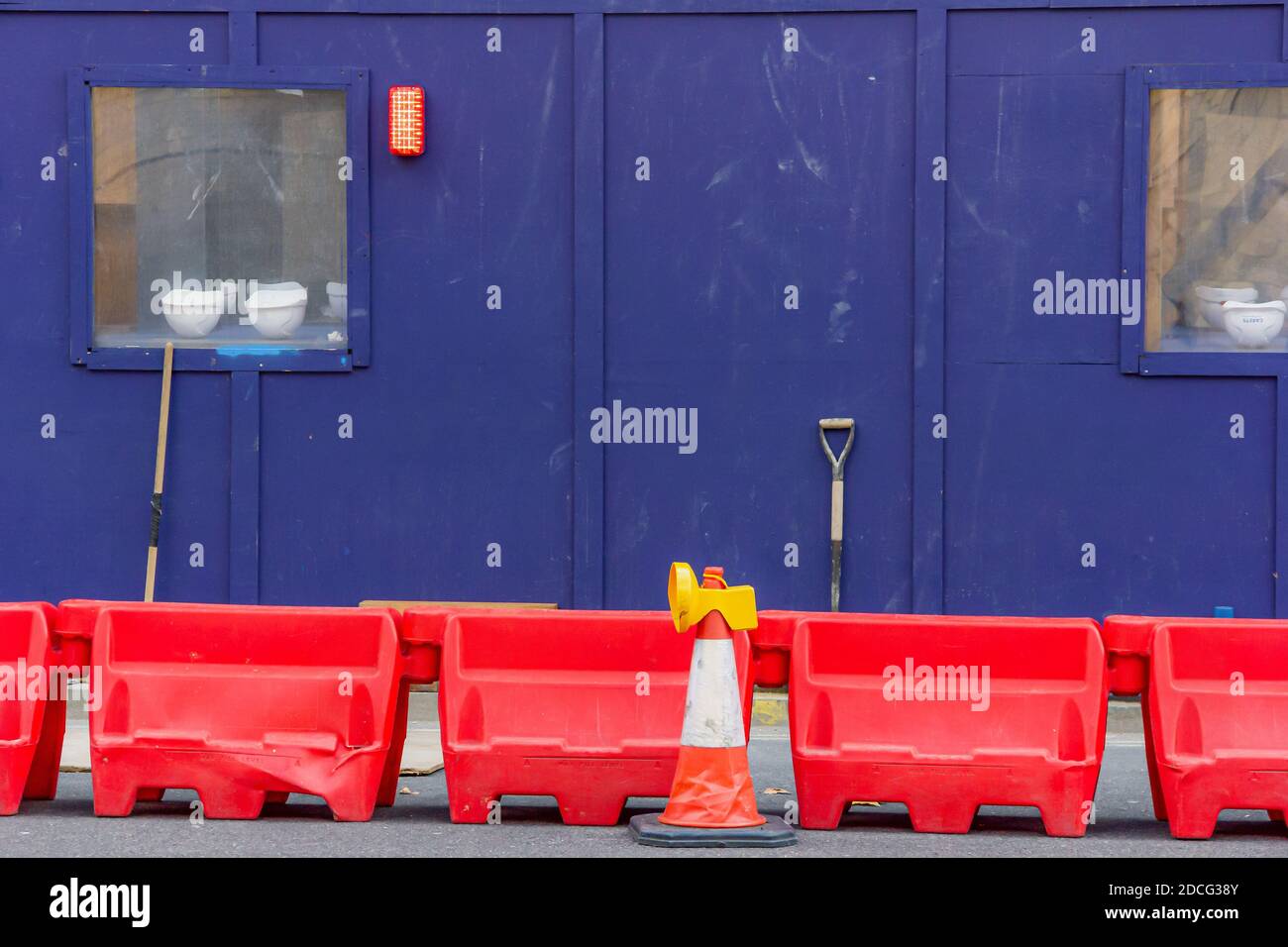construction container behind barrier with windows, helmets and tools ...