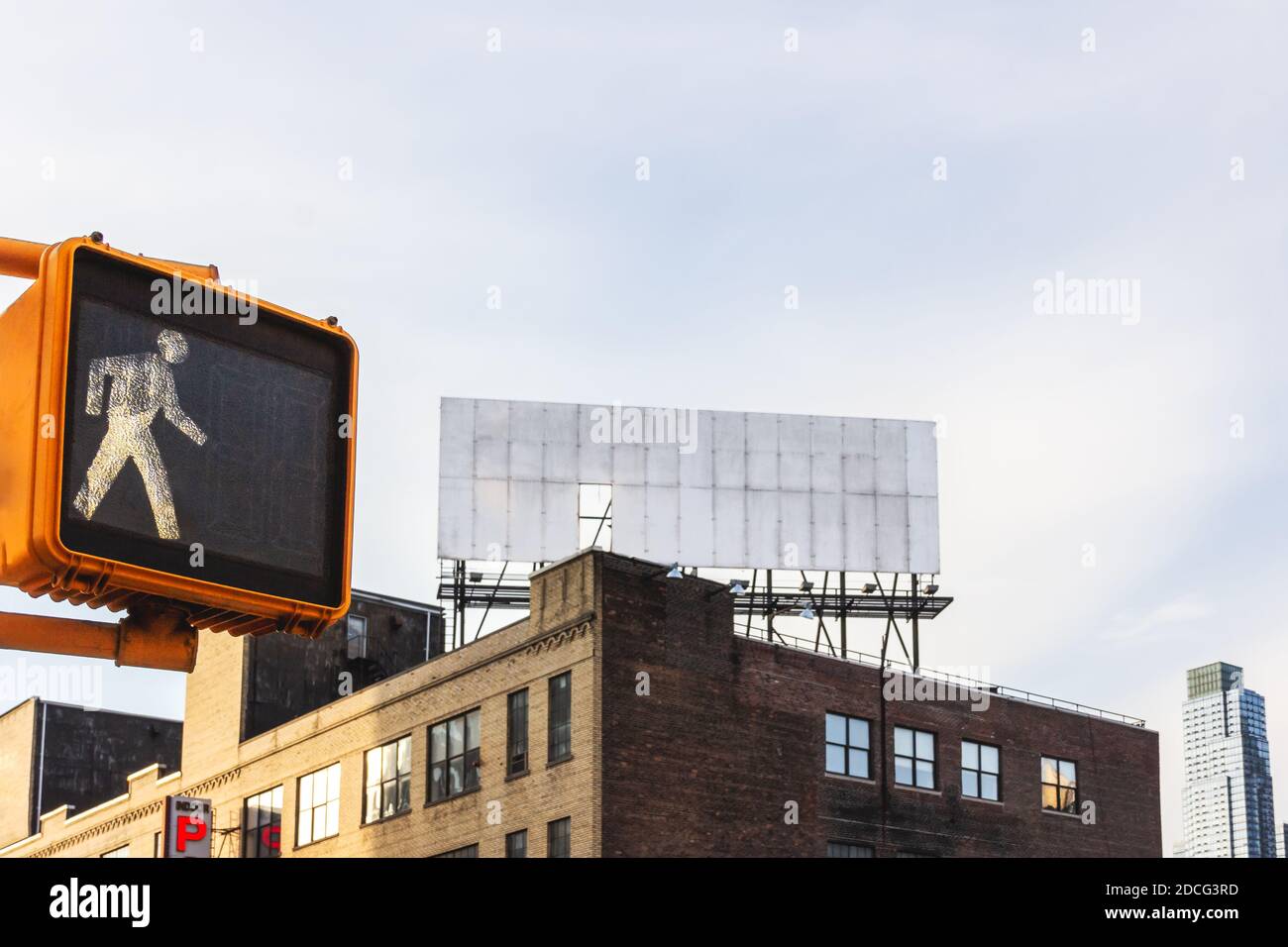 orange pedestrian traffic light and empty billboard on a roof. Exit to ...