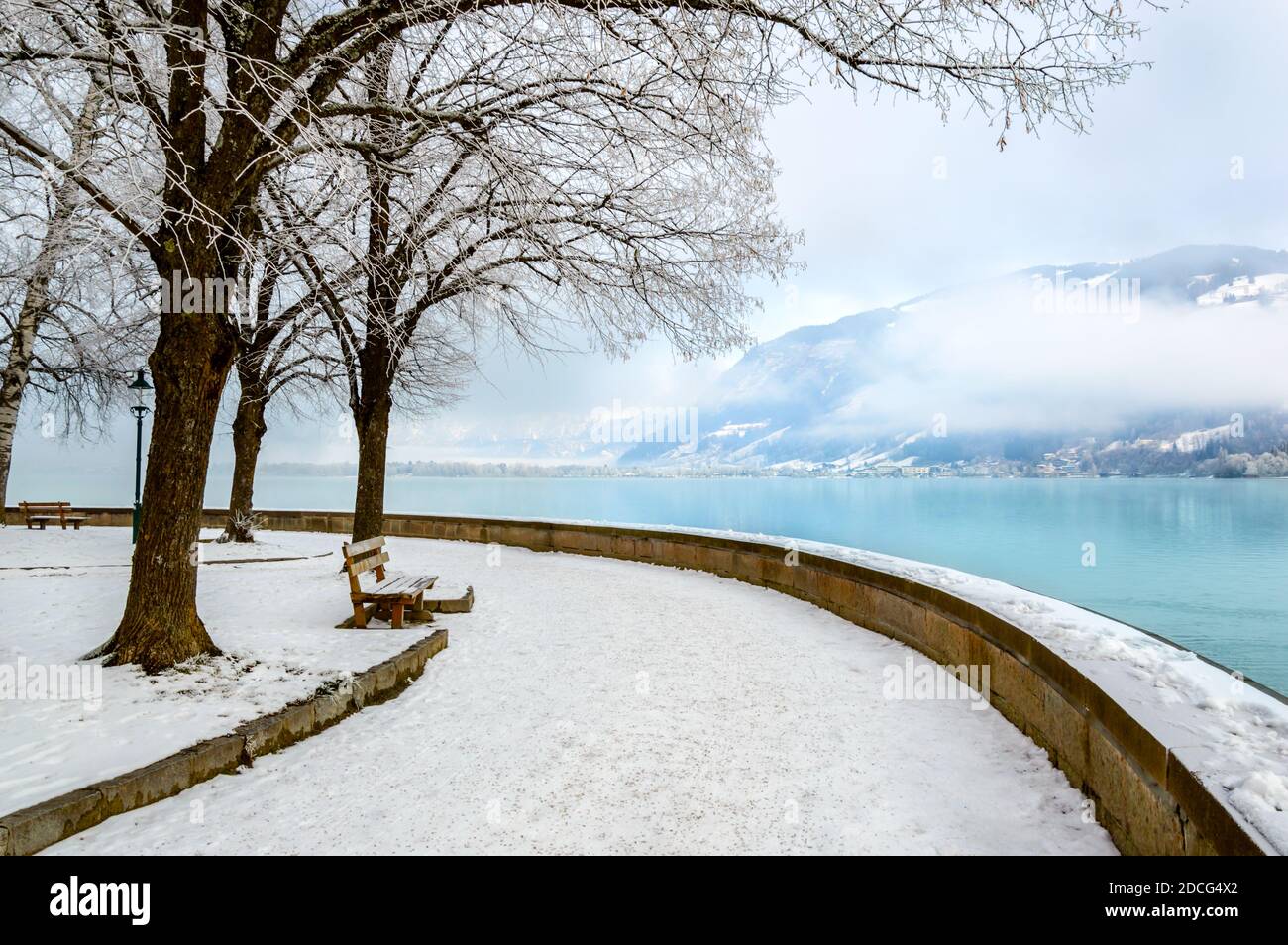 Zell am See in winter. Esplanade along Lake Zell, snow, frozen trees ...