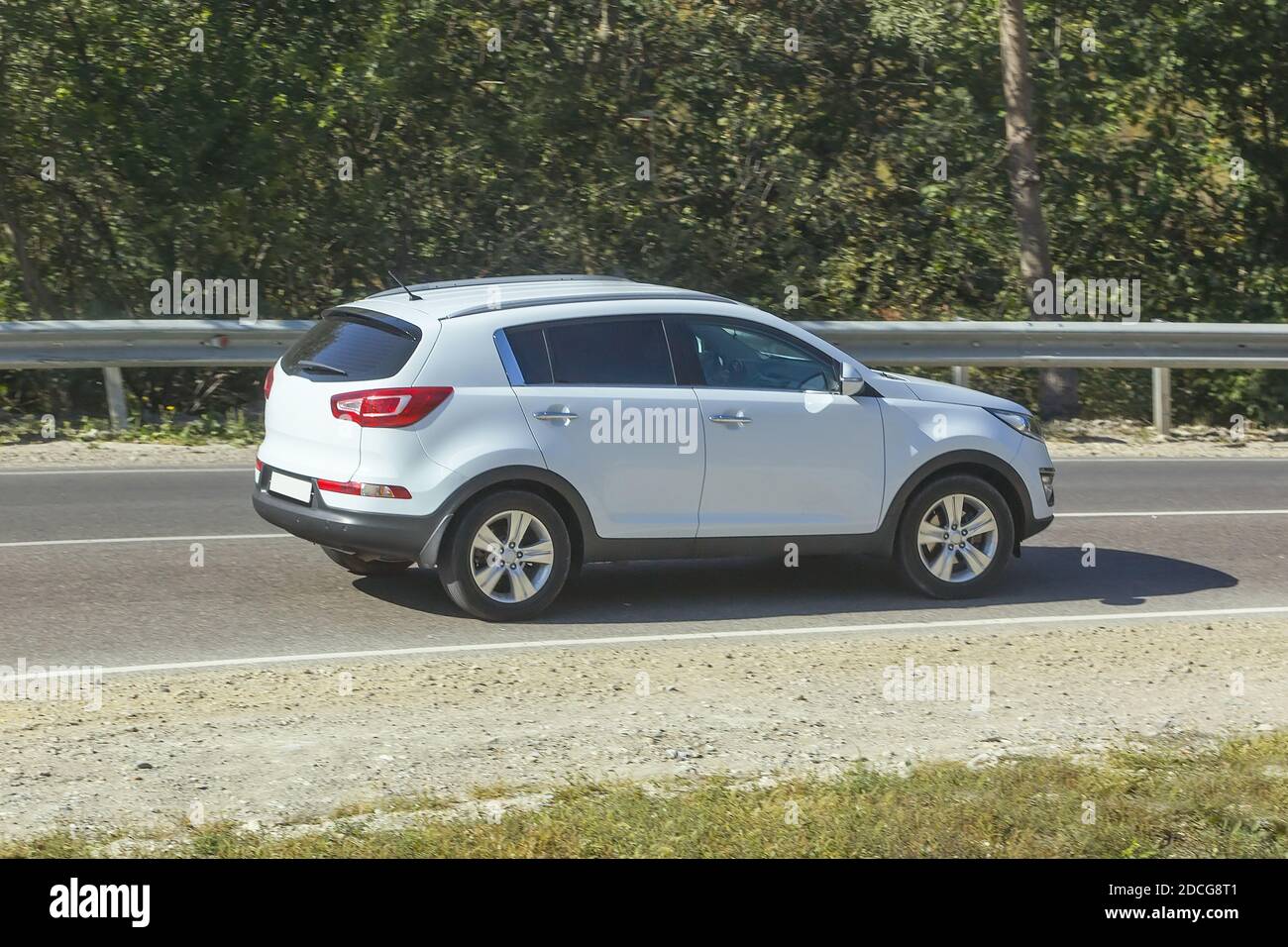 White crossover moves along an asphalt road Stock Photo - Alamy