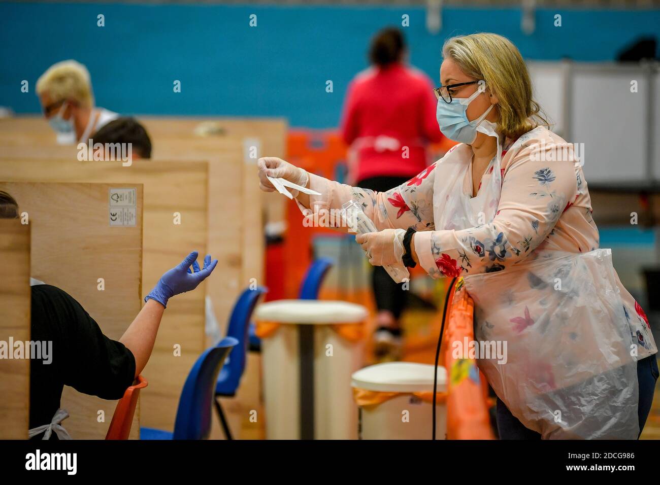 Testing staff members recieve swabs as part of the lateral flow testing ...
