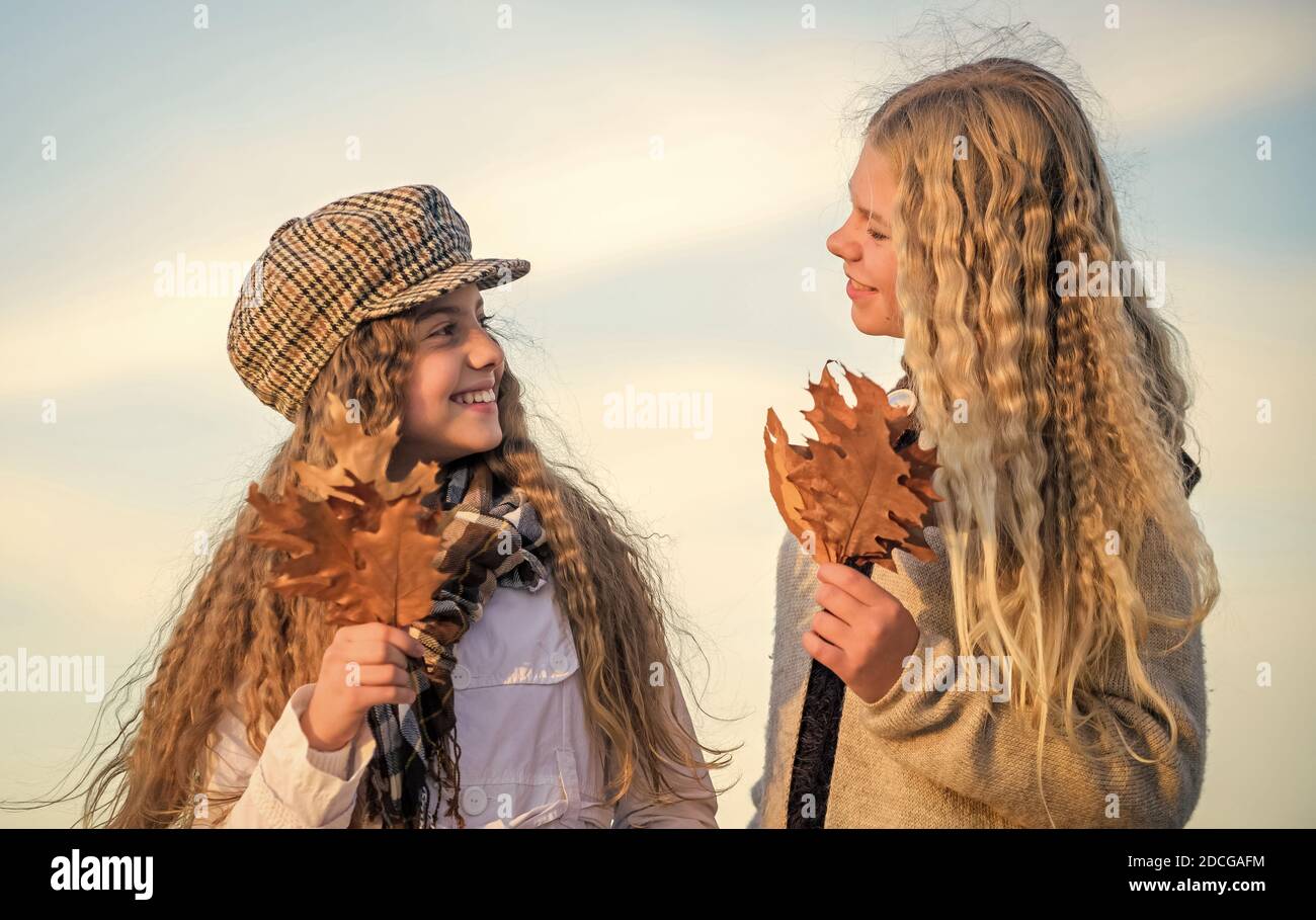 Happy to be around. children friends autumn leaf. stylish sisters in ...