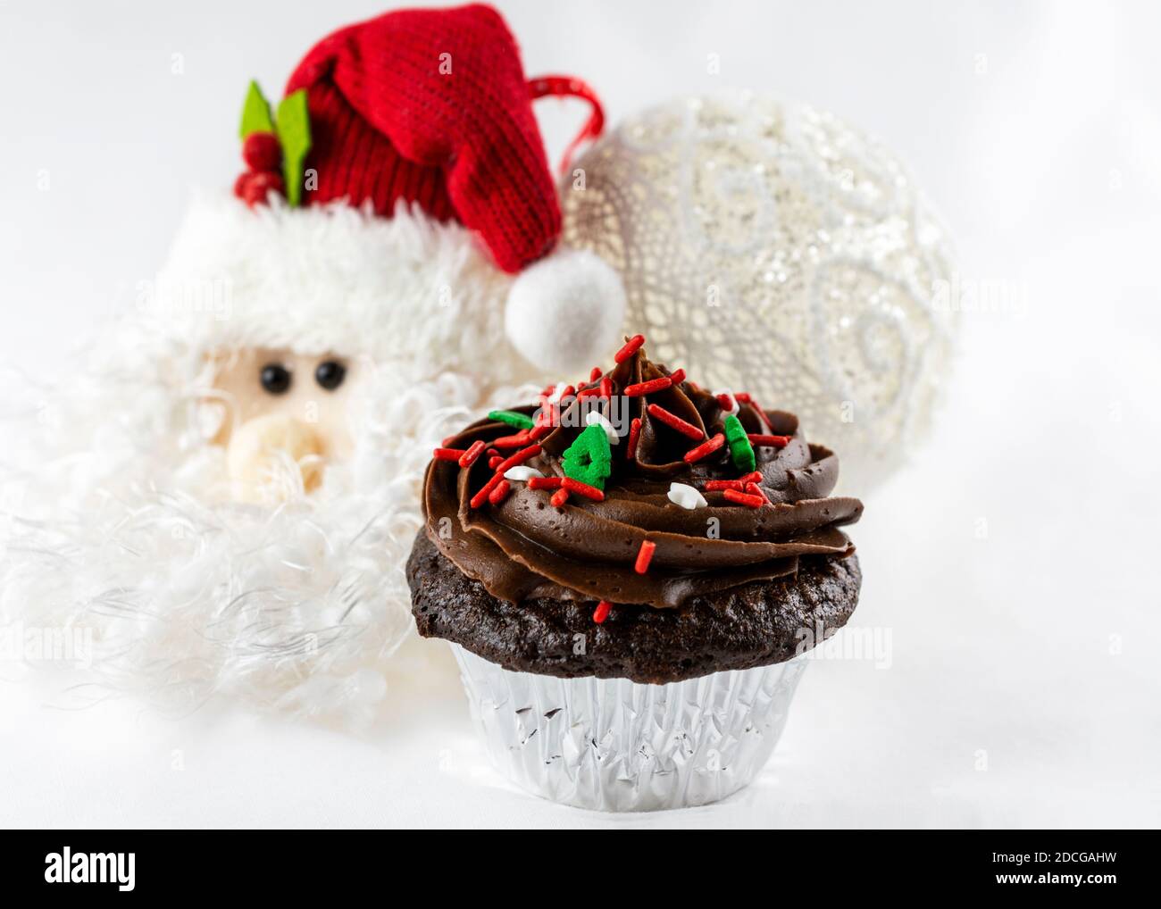 A close up shot of a Christmas chocolate cupcake with candy sprinkles ...