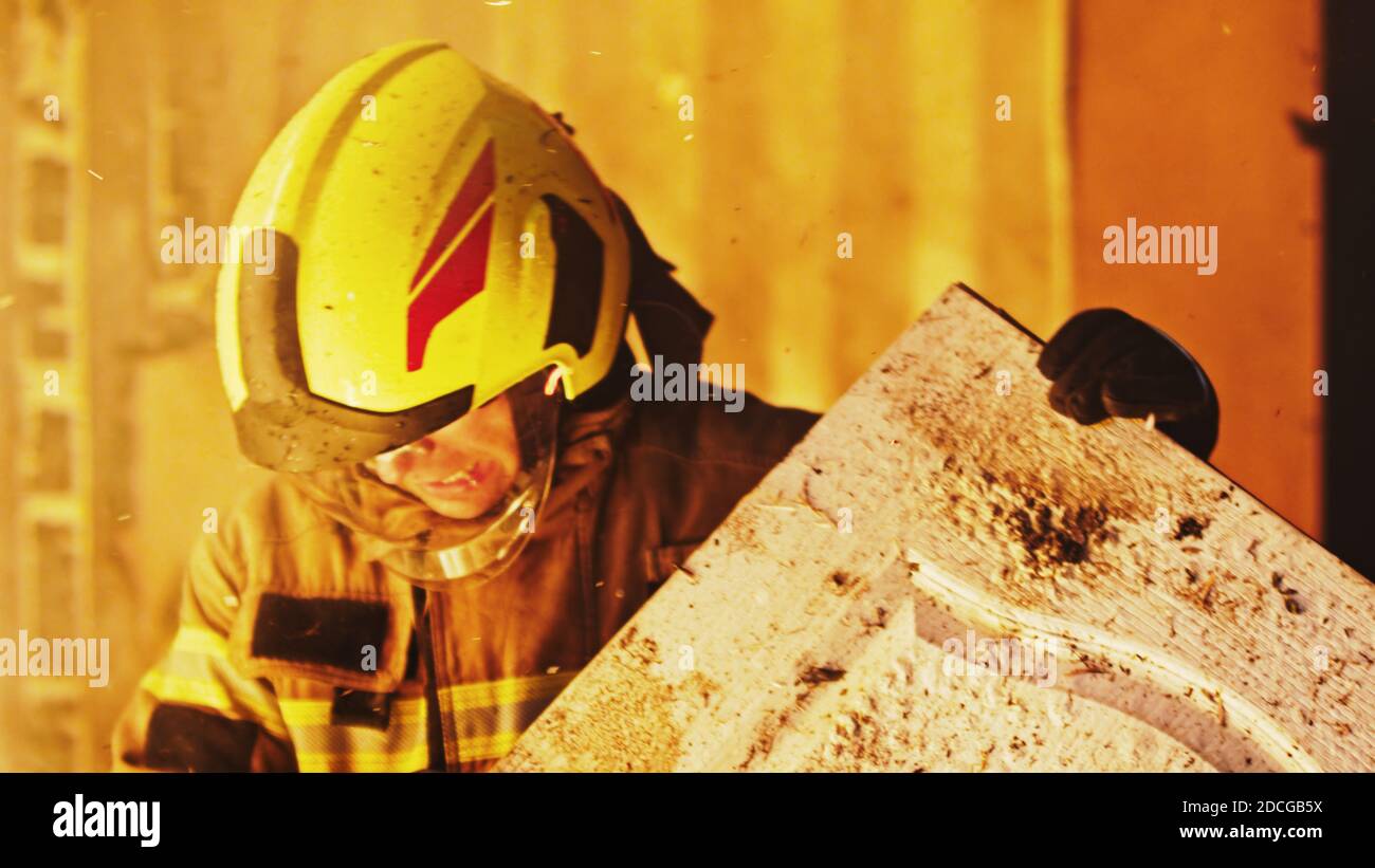 Firefighter helping to extinguish fire in burning house. High quality ...