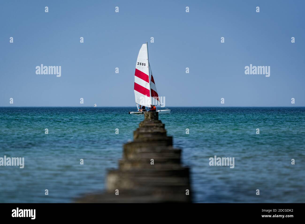 sailboat on the sea at the end of the pier Stock Photo - Alamy