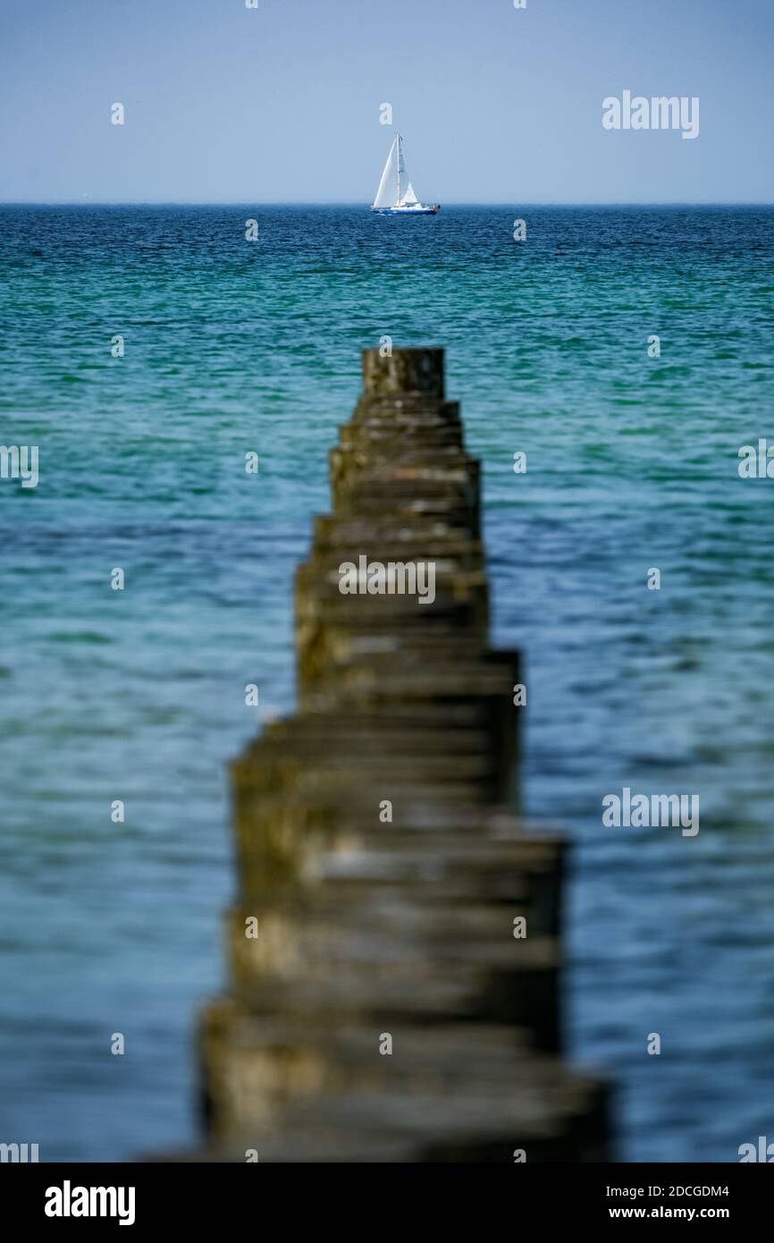sailboat on the sea at the end of the pier Stock Photo - Alamy