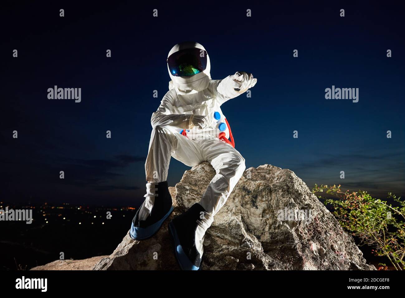 Front view of astronaut pointing at something while resting on top of ...