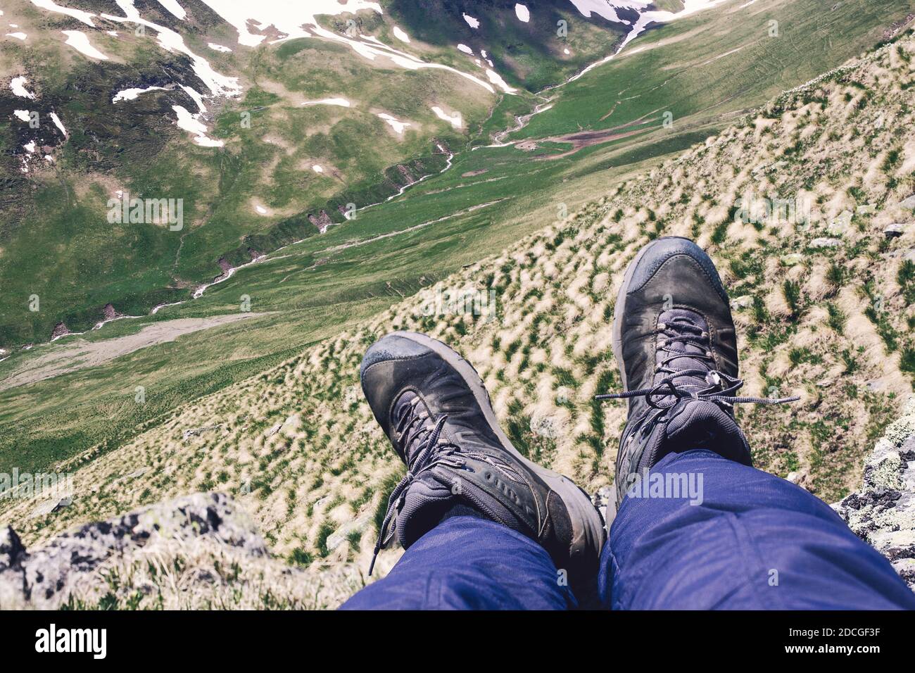 Man Traveler sitting on cliff bridge edge with mountain valley aerial ...