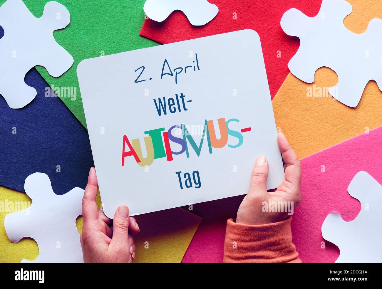 Hands hold board. Text in German means April 2 Autism World Awareness ...