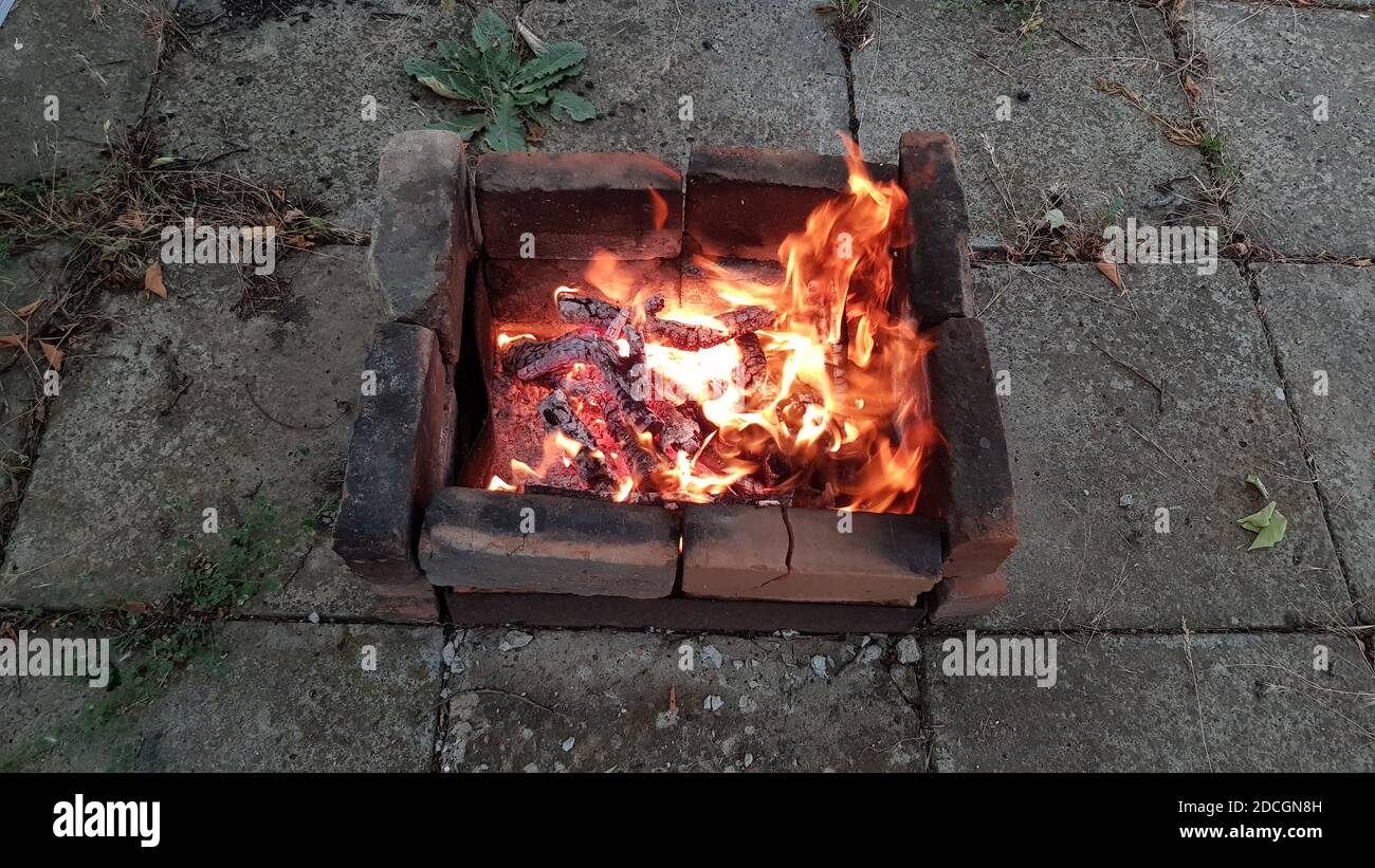 Orange color flaming fire inside grunge brazier. Picnic campfire for ...