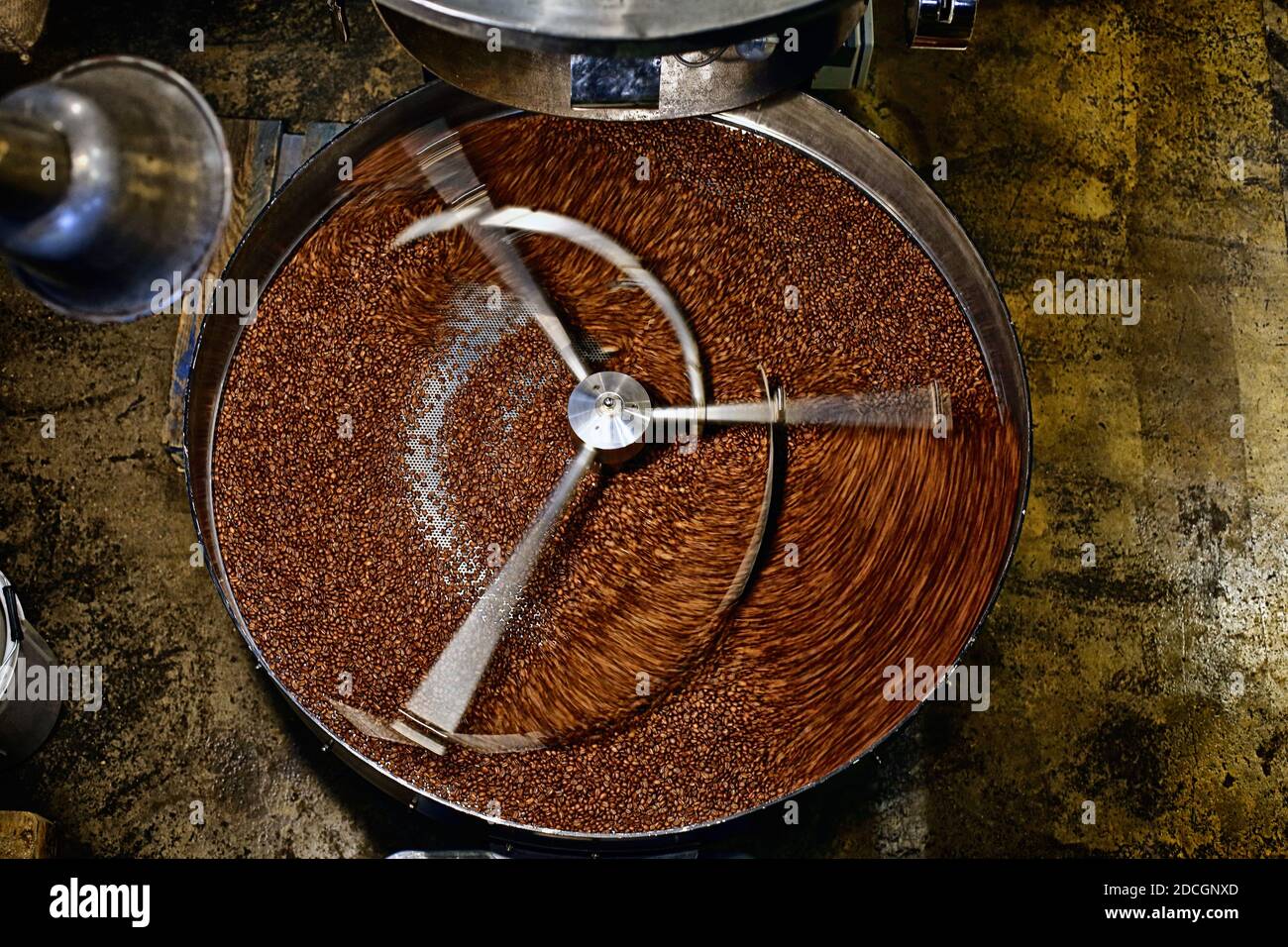 The freshly roasted coffee beans from a large coffee roaster being ...