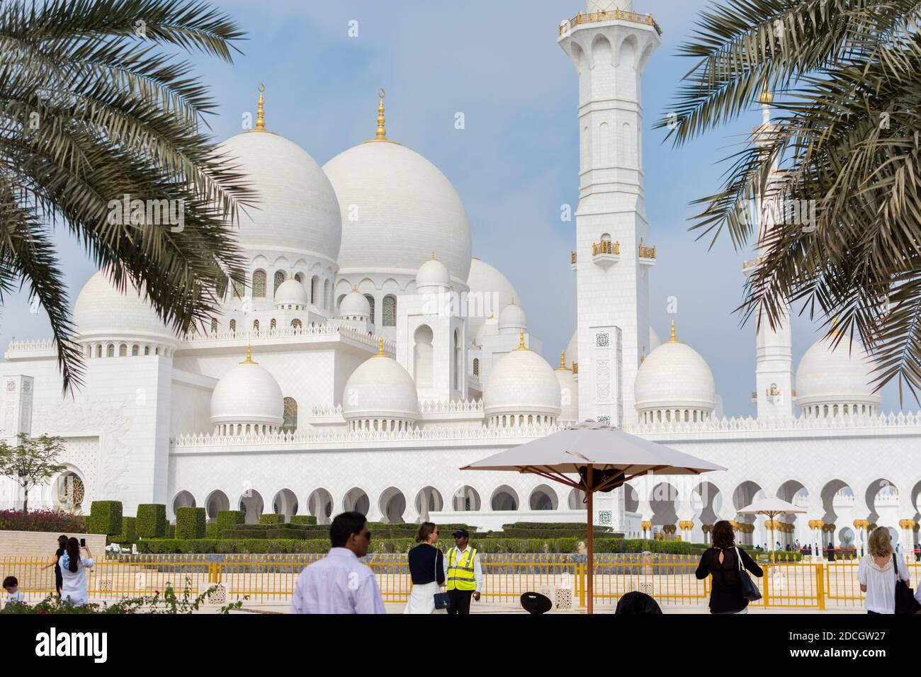 Tourists visiting white Grand Mosque against blue sky, also called ...