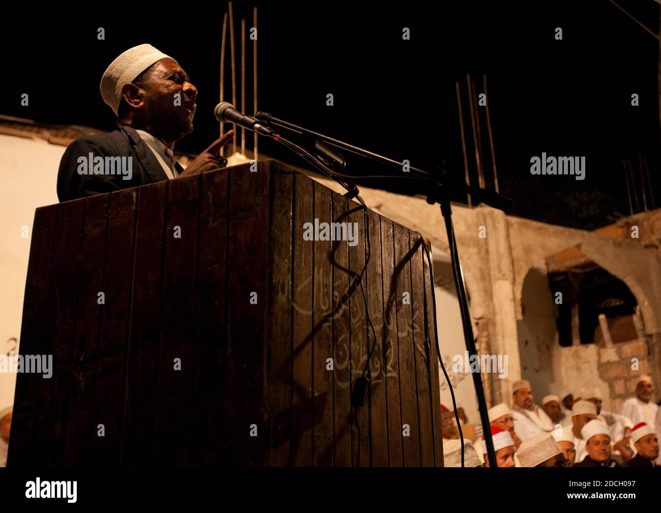 A muslim man speaking in a microphone during Maulid festival, Lamu ...