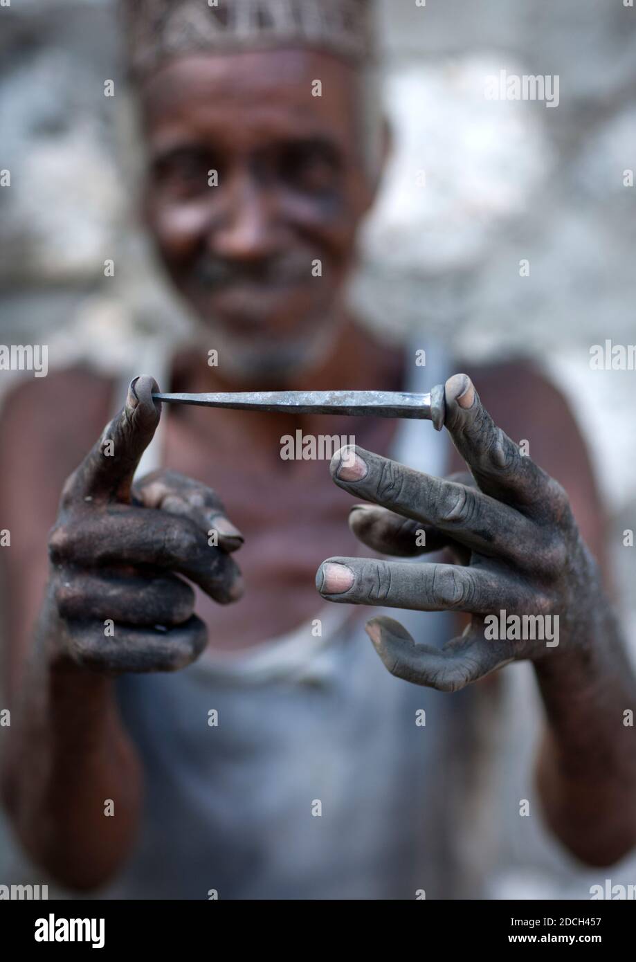Blacksmith showing a forged nail for the boats, Lamu county, Matondoni ...