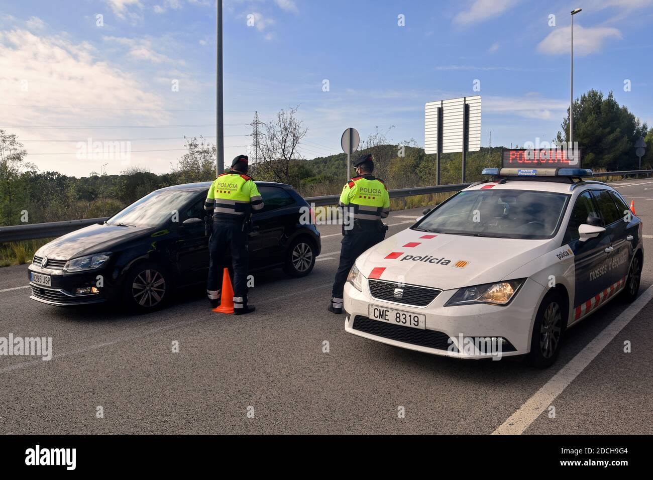 Two Catalonia Police officers approach a vehicle at a perimeter control ...