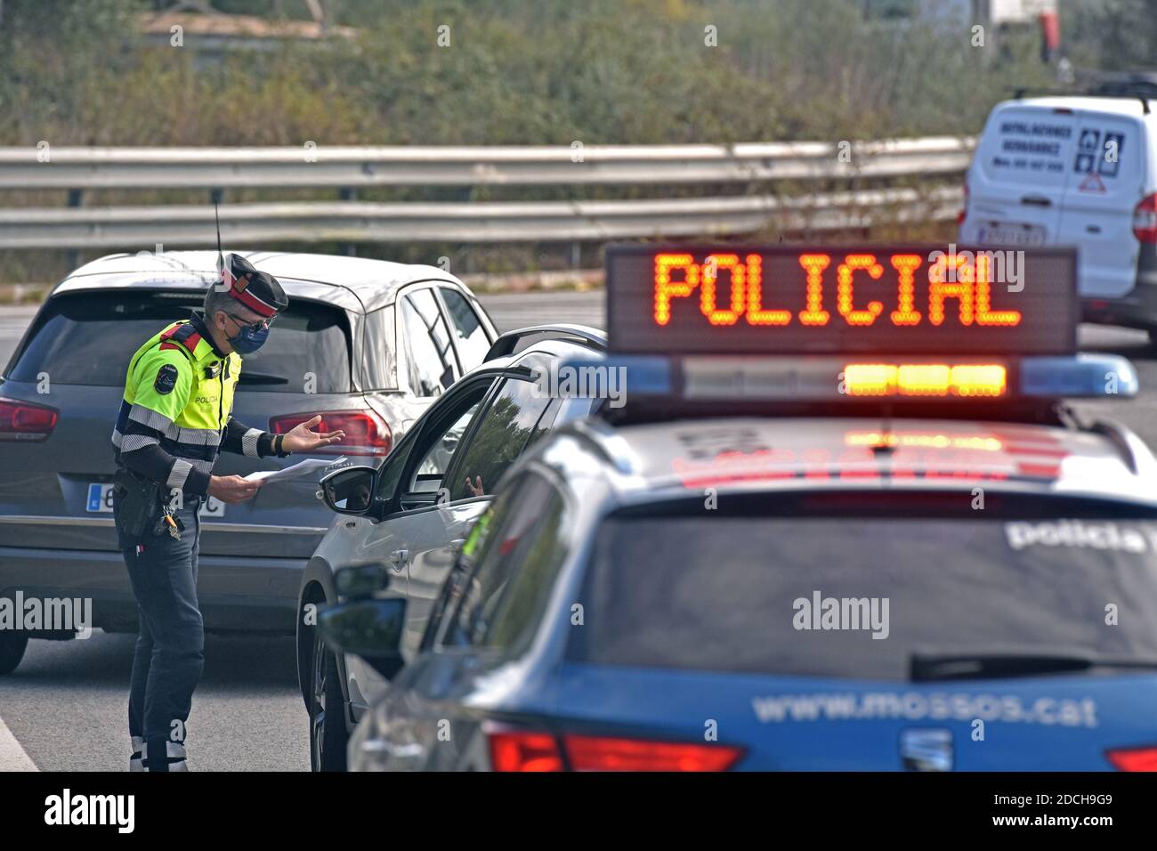 A Catalonia police officer inspects the mobility certificate of a ...
