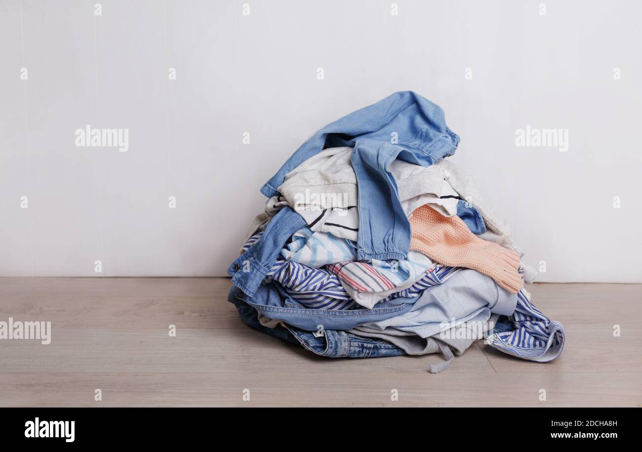 a pile of colorful clothes lying on the floor on a light background ...