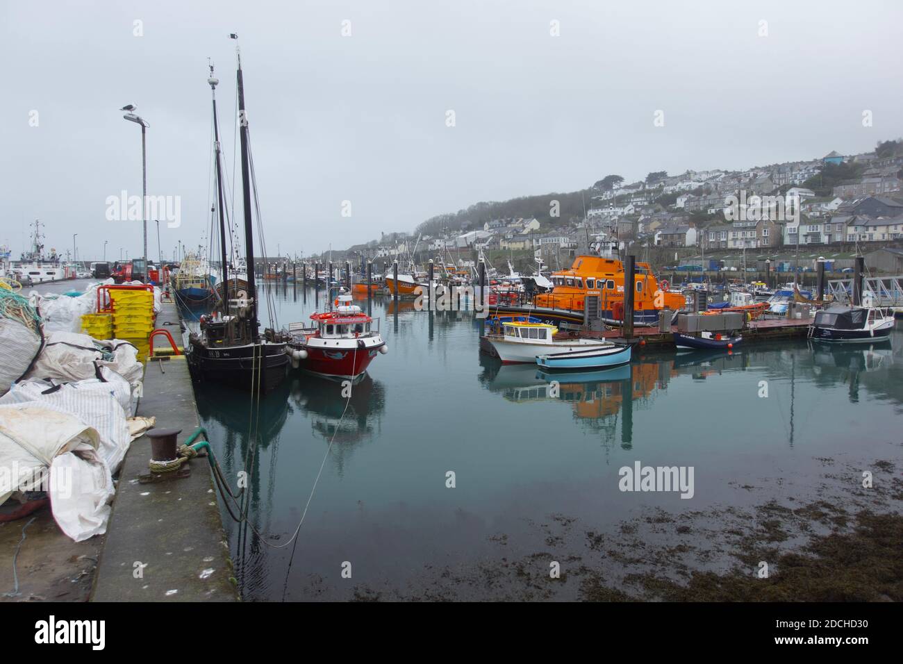The fishing harbour of Newlyn in Cornwall, UK where a lifeboat is ...