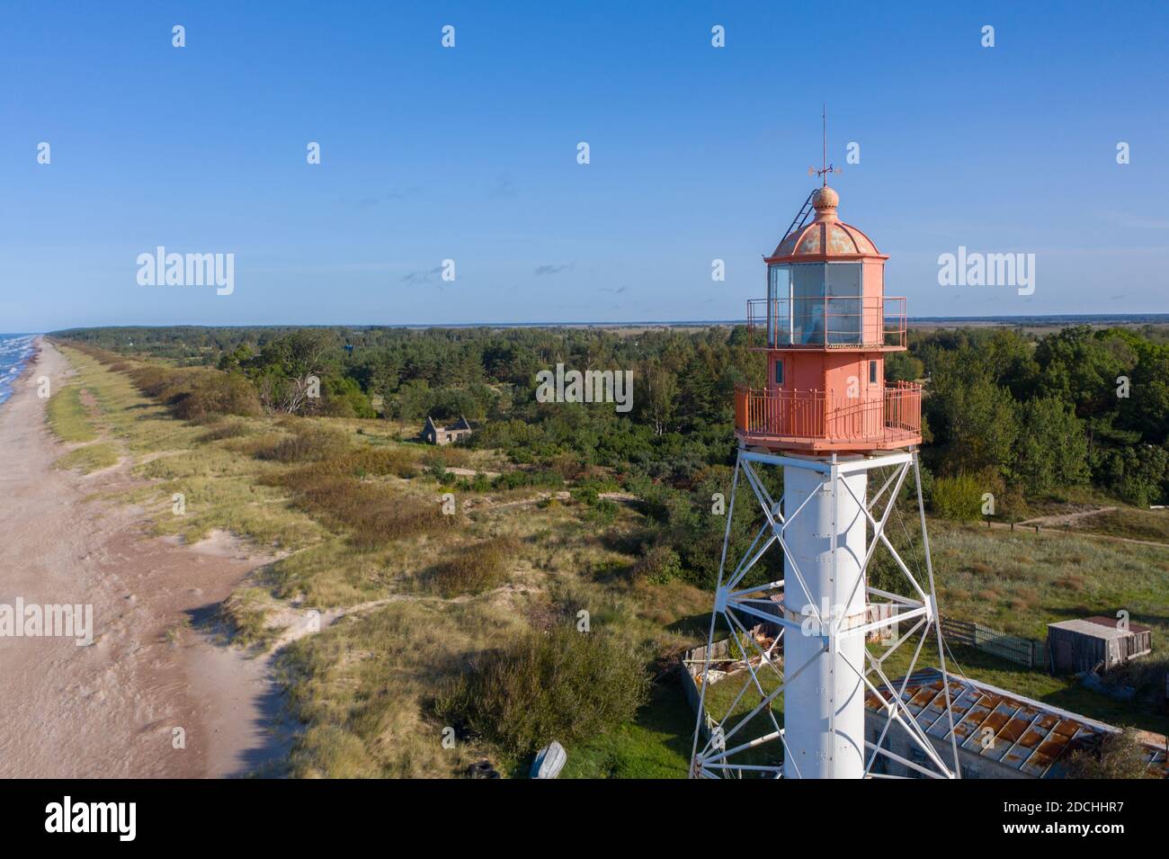 Aerial view of lighthouse with red top and white base. Blue sky and sea ...