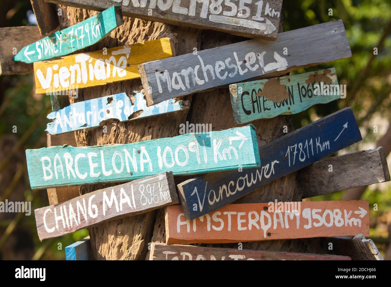 Colourful hand painted direction wood signs to different cities of the ...
