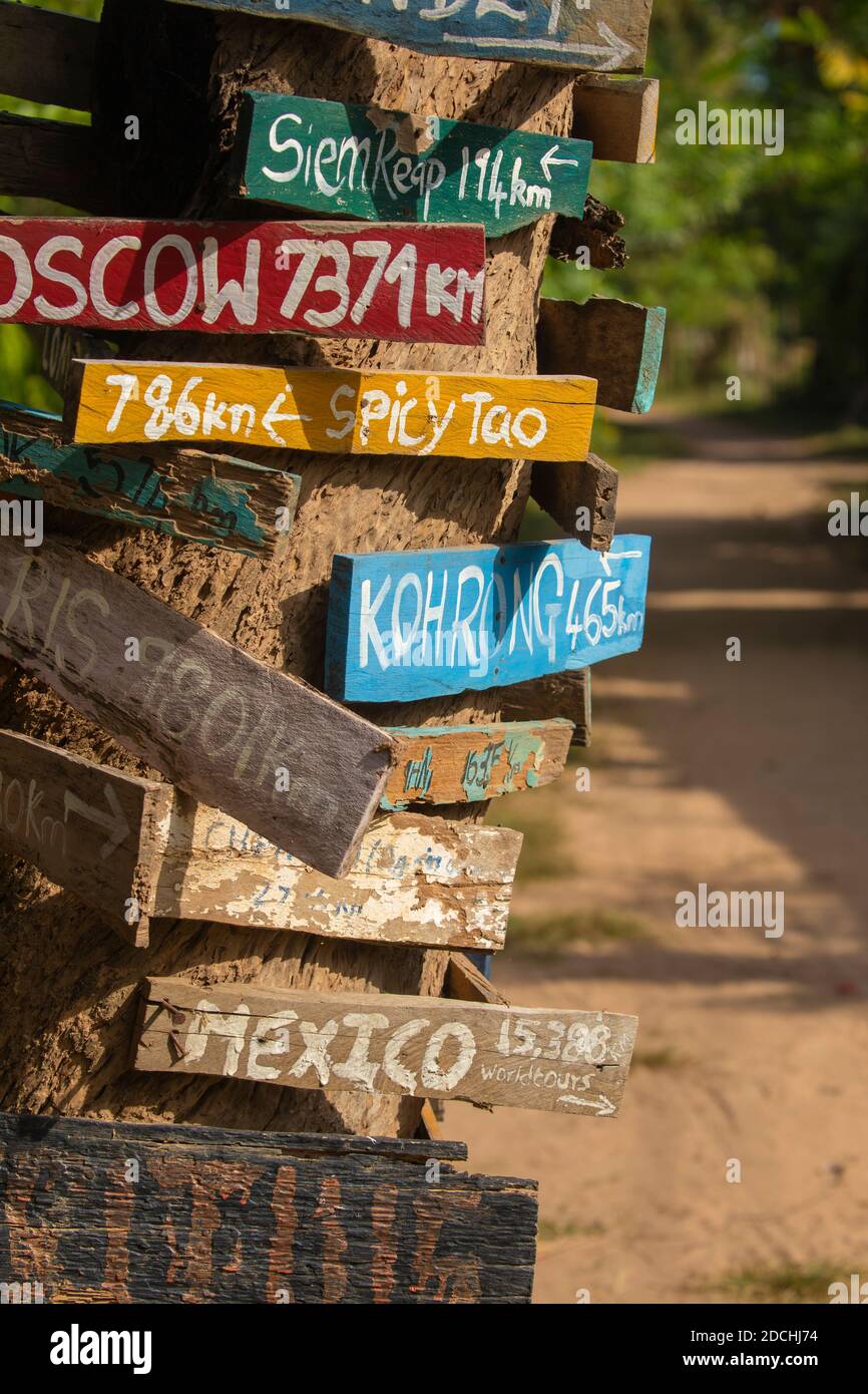 Colourful hand painted direction wood signs to different cities of the ...