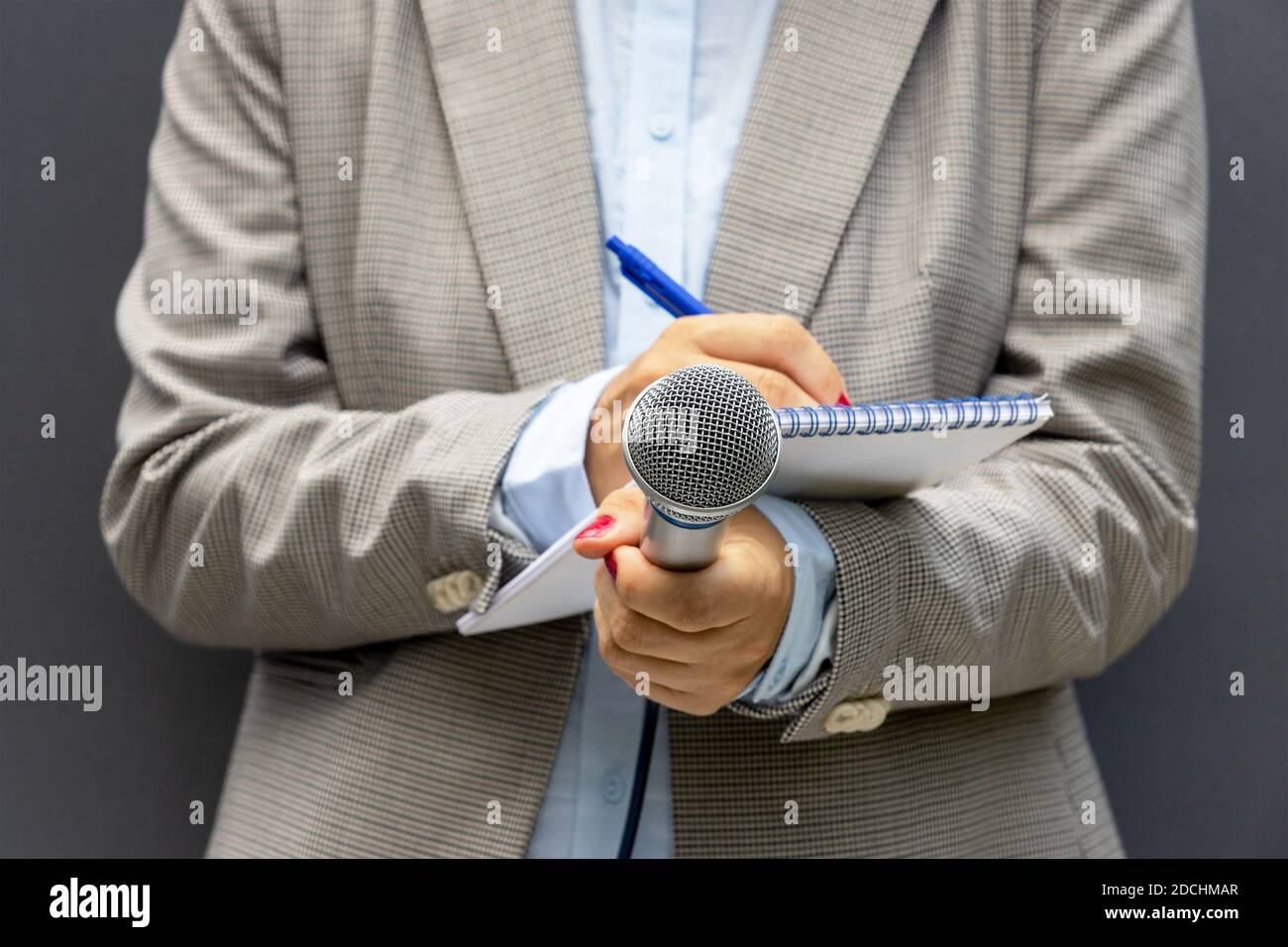 Female reporter at press conference or media event, writing notes ...