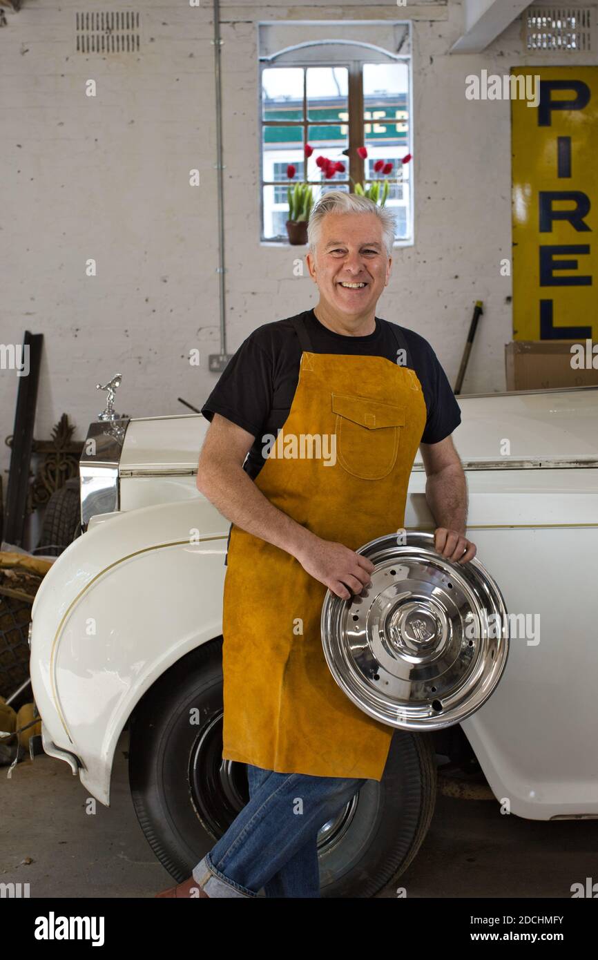 mechanic holding wheel cap Stock Photo - Alamy