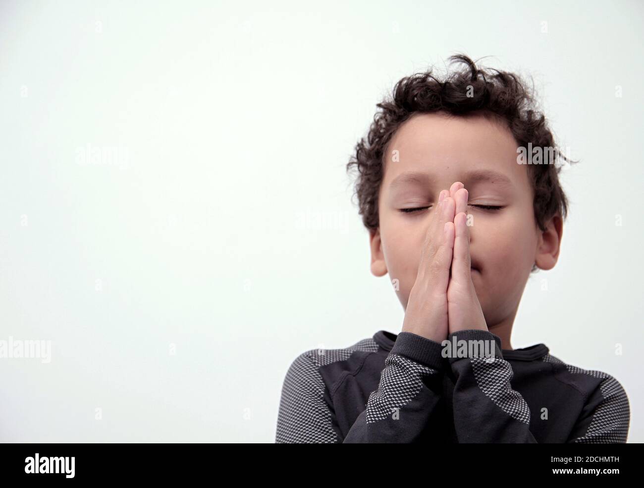 boy praying to god with hands together stock photo Stock Photo - Alamy