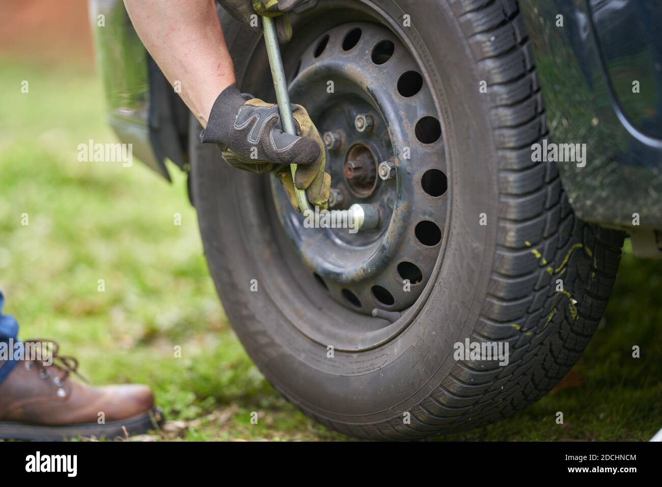 Man changing a flat tyre on his car by himself Stock Photo - Alamy