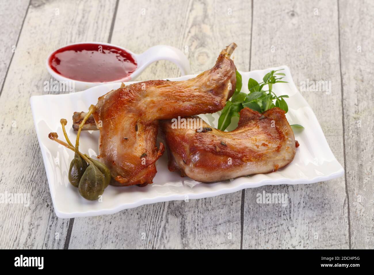 Roasted rabbit legs with cowberry sauce Stock Photo - Alamy
