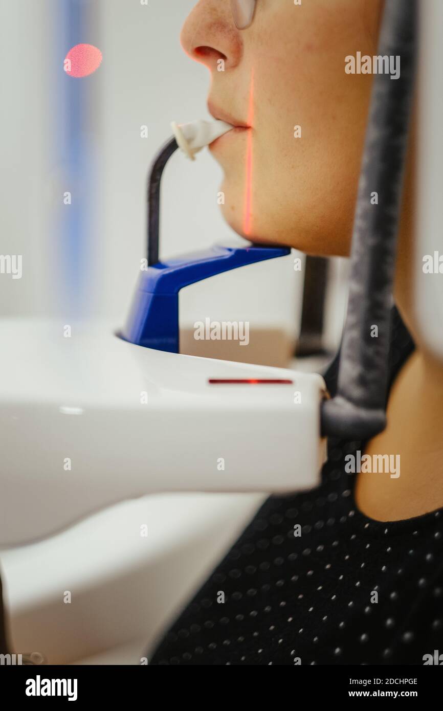 A vertical closeup shot of a dental patient using panoramic radiography ...