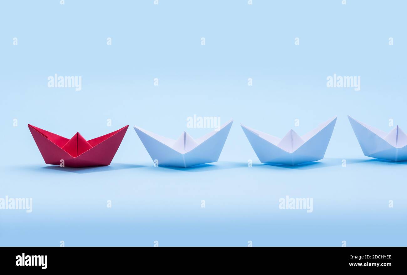 Red and white paper boats. Concept of leadership boats for teamwork ...