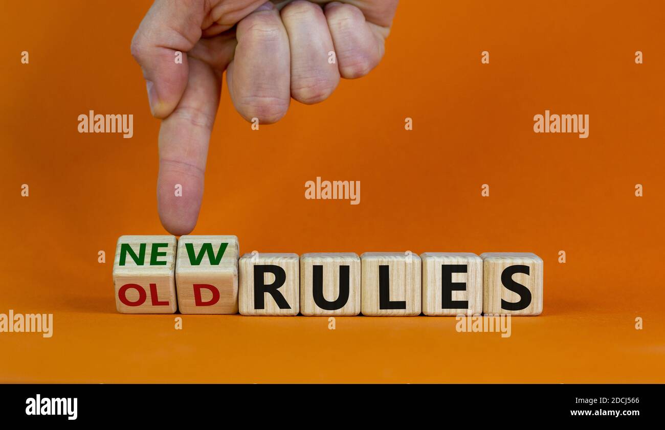 Male hand turns cubes and changes words 'old rules' to 'new rules' on a ...