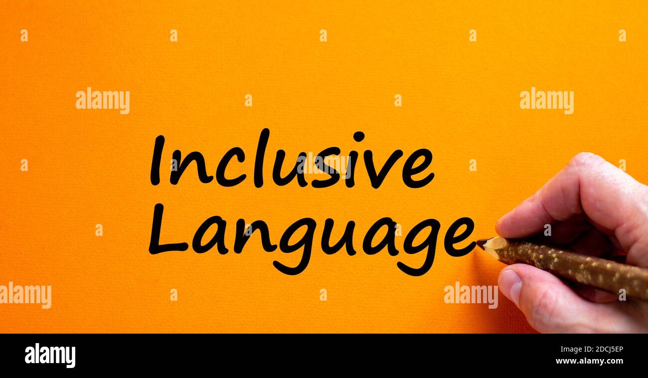 Hand writing 'inclusive language', isolated on orange background ...