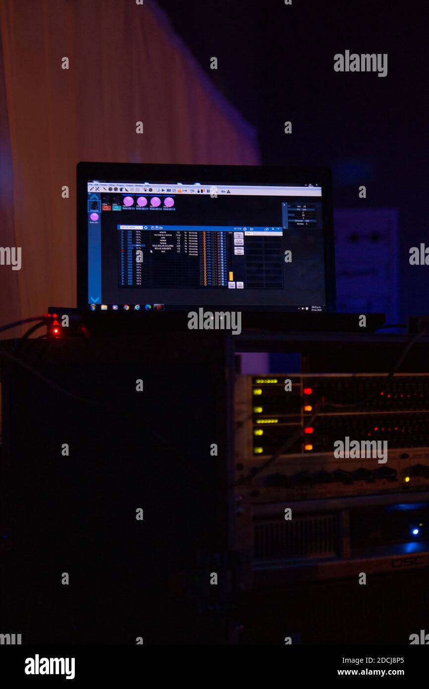 A vertical shot of a DJ table setup with sound control screen and ...