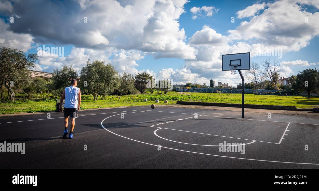 Man in a basketball court under a dramatic sky Stock Photo - Alamy