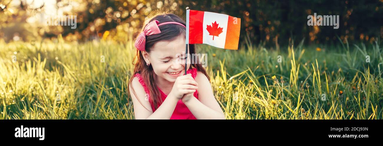 Funny Caucasian girl holding Canadian flag. Laughing child in park ...