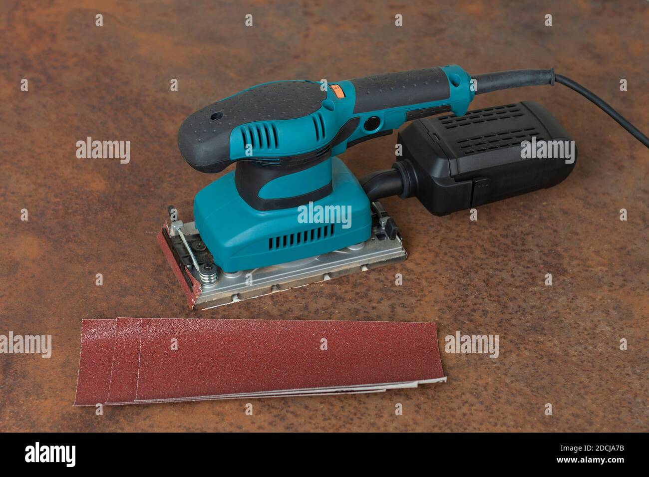 Electric sheet finishing sander and three abrasive papers on old rusty ...