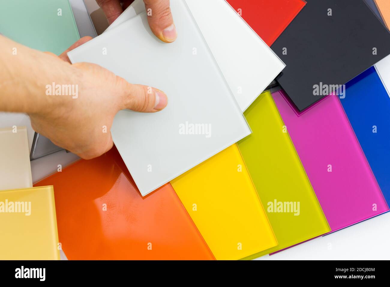 Colored glass for interior finishing. The craftsman shows samples of ...